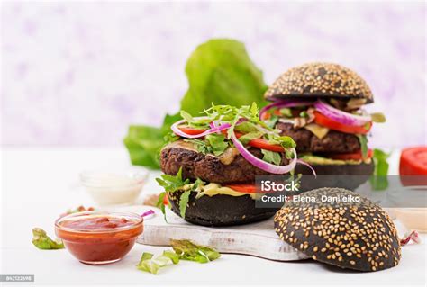 수 분이 많은 쇠고기 햄버거 치즈 토마토 그리고 밝은 배경에 빨간 양파와 검은 큰 샌드위치검은 햄버거 0명에 대한 스톡 사진 및 기타 이미지 Istock