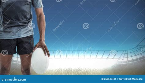 Composition Of Male Rugby Player Holding Rugby Ball Over Sports Stadium