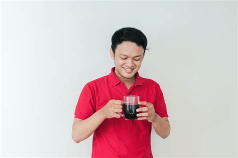 고립된 흰색 배경 위에 서있는 커피 한 잔을 들고 있는 젊은 아시아 남자는 큰 미소로 행복합니다 20 29세에 대한 스톡 사진 및 기타 이미지 Istock