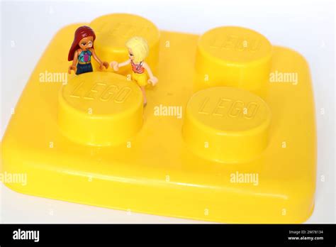 2 Lego Girls Figure Holding Hands Standing On A Large Yellow Block