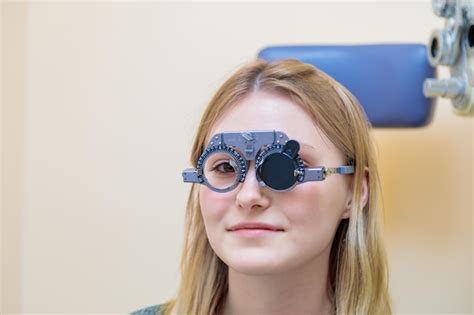 Premium Photo A Male Optometrist Checks The Eyesight Of A Young Girl With A Trial Frame