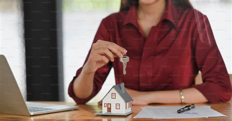 젊은 자신감 소녀가 웃으며 현대 사무실의 업무용 책상에 앉아 열쇠를 보여주는 장면 사진 Unsplash의 집 열쇠 이미지