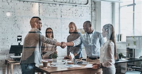 스마트 캐주얼을 입은 젊은 현대 남성들은 회의실의 유리 벽 뒤에 동료들과 함께 서서 악수를 하고 있습니다 사진 Unsplash의 사무실 이미지