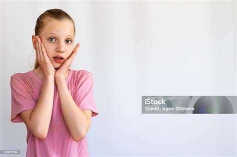 얼굴에 손을 얹고 충격을 받은 소녀 놀란 어린 소녀는 양손으로 얼굴을 잡고 충격이나 놀라움을 표현하며 흰색 배경에 고립되어 있습니다 텍스트를 위한 공간입니다