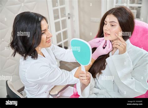 Female Patient Discussing With Dermatologist Mole Removal During