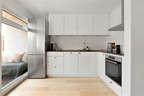 흰색 캐비닛과 나무 바닥이 있는 주방입니다 사진 Unsplash의 무료 사람의 이미지