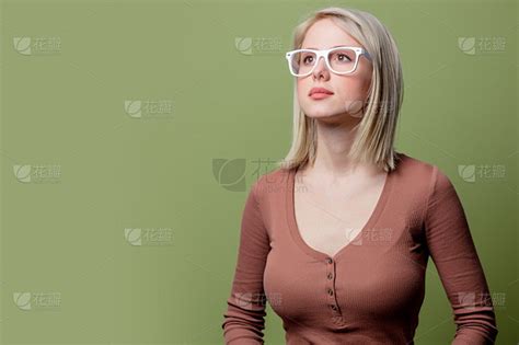 漂亮的金发女孩，戴着眼镜，穿着棕色衬衫
