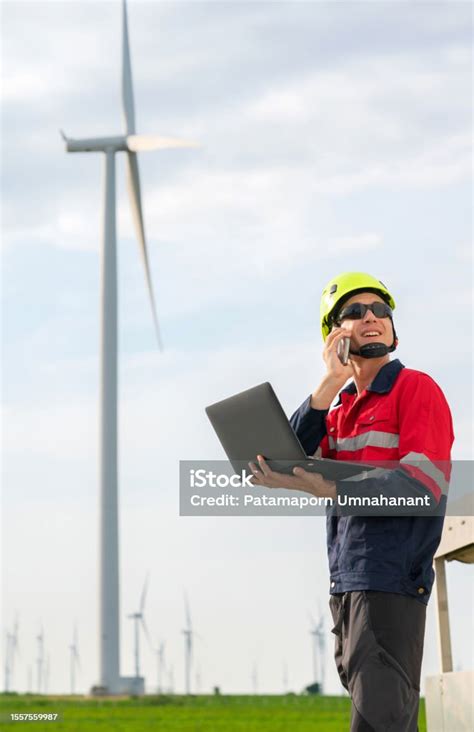 광대한 풍력 터빈 농장에서 일하는 기계 엔지니어는 노트북을 사용하여 중요한 매개변수를 모니터링하고 풍력 터빈을 살펴봅니다 최적의 성능과 에너지 생성을 보장하기 위해 데이터를
