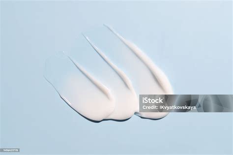 파란색 배경에 흰색 크림의 질감입니다 모이스처 라이저의 얼룩이 닫힙니다 로션 견본 뷰티 스킨 케어 제품 얼룩 얼룩 파란색 배경에 Spf 자외선 차단제 크림 샘플 보습제에