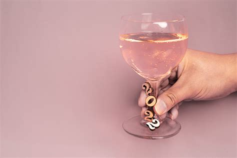 2022년 새해 전야 수평 컬러풀한 이미지를 축하하기 위해 샴페인 한 잔을 손에 들고 있는 사람 12월 31일에 대한 스톡 사진 및 기타 이미지 Istock