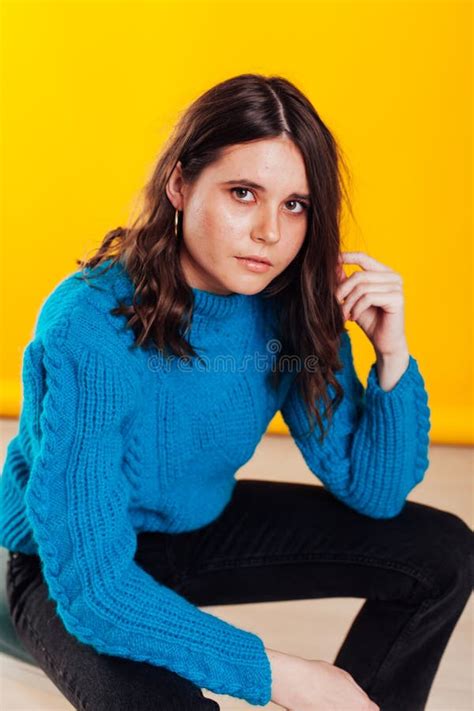 Portrait Of A Skinny Fashionable Brunette Woman In Jeans And A Blue