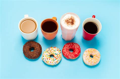 뜨거운 음료 커피 카푸치노 파란색 배경에 차와 맛있는 도넛과 컵 과자 빵집 패스트리 커피 숍 회의 친구 친절한 팀의 개념 플랫