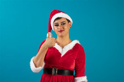 산타클로스 복장과 모자를 쓴 젊은 여성 파란색 배경과 크리스마스 테마가 있는 스튜디오 사진 12월에 대한 스톡 사진 및 기타 이미지 Istock