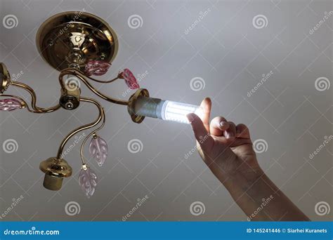 Female Hand Inserts A Light Bulb Into The Threaded Socket She Is Shining Installation Of