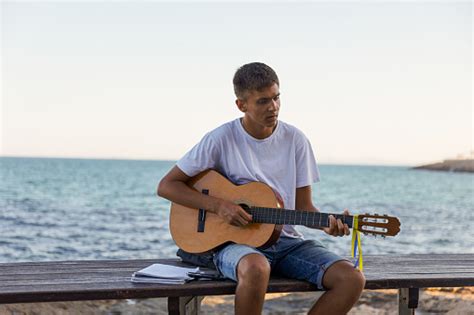 젊은 세련된 남자가 바다 제방에서 기타를 연주 음악과 휴식의 개념 가수에 대한 스톡 사진 및 기타 이미지 가수 거리 기타 연주자 Istock