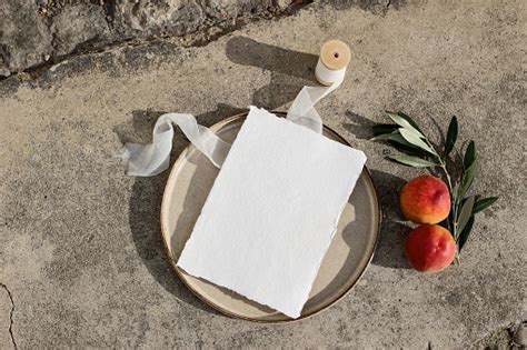 여름 웨딩 문구 햇빛에 세라믹 접시에 빈 인사말 카드 모형 실크 리본 복숭아 과일과 올리브 가지를 콘크리트 배경에 여성스러운 평지 탑 뷰 사람 도 없습니다 결혼식에 대한