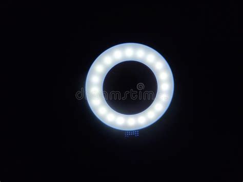 A Circular Led Ring Light Glows Softly Against A Dark Background Stock