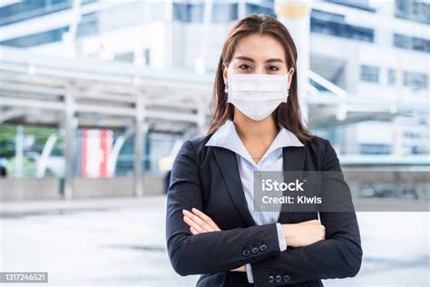 새로운 정상적인 라이프 스타일을 가진 도시에서 야외에 서있는 젊은 아시아 사무실 비즈니스 여성 보호 얼굴 마스크를 착용 하는