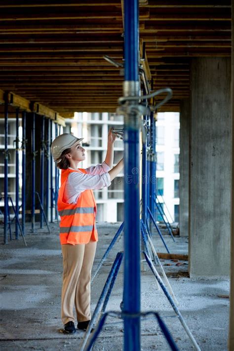 Confident Female Builder Checks Fastenings On A Monolithic Structure Construction Concept Stock
