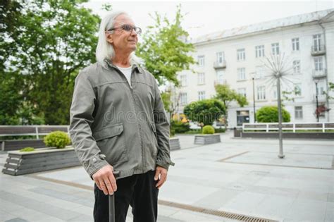 Anciano Camina Con Una Vara En Un Parque Primaveral De La Ciudad