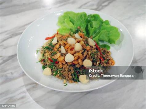 볶음 튀김의 흰색 플레이트 트위스트 클러스터 콩 또는 쓴 콩 또는 콩 절인된 마늘과 말린된 새우와 등반 Wattle 악취 선택적 초점 남부 전통 태국 음식입니다 0명에 대한