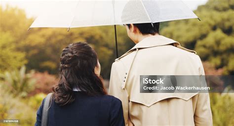 로맨스 유대감 및 관계를 위해 공원을 걷는 커플과 함께 사랑 뒤로 우산 일본의 남녀 자연 데이트를 위한 휴가 집념 평화를 함께 응원 배려 침착 20 24세에 대한 스톡 사진