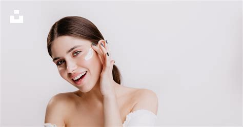 흰 셔츠를 입은 여성이 미소를 지으며 얼굴을 만지고 있습니다 사진 Unsplash의 무료 초상 이미지