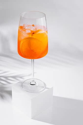 Aperol Spritz 칵테일 흰색 큐브에 서 흰색 배경에 그림자를 드리우고 있습니다 0명에 대한 스톡 사진 및 기타 이미지