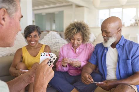 Group Of Mature Friends At Home Having Fun Playing Cards Together Stock