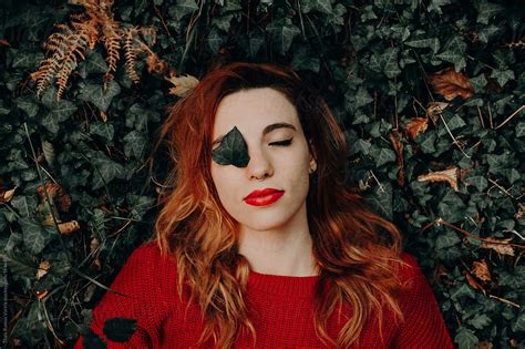 Portrait Of A Ginger Woman Lying On A Bed Of Vegetation With A Leaf On Her Face Del