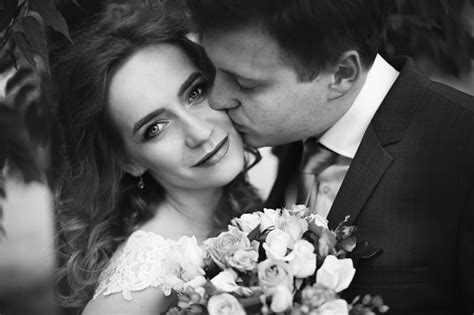 아름 다운 화려한 신부 및 신랑의 키스 행복 한 웨딩 커플 녹색 정원에서 포옹입니다 행복 한 로맨틱 순간입니다 주 개념입니다 관능적인 사랑 2명에 대한 스톡 사진 및 기타