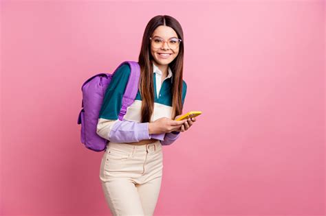분홍색 배경에 포즈를 취하는 배낭과 스마트 폰을 가진 웃는 젊은 사랑스러운 여자의 사진 14 15 살에 대한 스톡 사진 및 기타 이미지 14 15 살 Brand