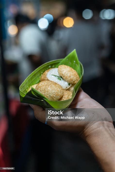 Kanom Krok 태국 치앙마이 치앙마이의 야시장에서 여자의 손에 일부 바나나 잎에 싸여 전형적인 태국 코코넛 팬케이크 길거리