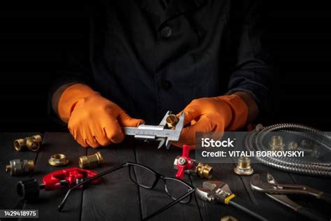 전문 배관공은 캘리퍼가있는 피팅의 직경을 측정합니다 가스 설치의 연결 도중 작업장의 노동 환경 가정 주방에 대한 스톡 사진 및