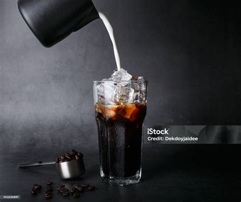 우유를 붓는 것은 투명한 유리에 아이스 라떼 커피를 만들고 검은 배경 스튜디오 사진에 볶은 커피 원두를 만듭니다 냉동된에 대한 스톡 사진 및 기타 이미지 Istock