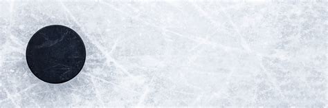 얼음 배경에 검은 오래 된 고무 퍽 근접 촬영 와이드 배너입니다 하향식 보기 텍스트를위한 빈 장소 아이스하키 선수에 대한 스톡