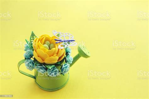 노란색 수제 인공 꽃 반짝이와 노란색 배경에 대한 미니어처 녹색 급수 캔에 종이 장미를 많이 잎 그리고 위에서 보라색 나비보기 복사 공간 0명에 대한 스톡 사진 및 기타