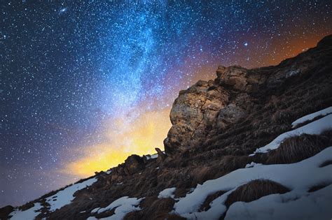 긴 노출에 밤 풍경입니다 찬은 하 고 바위 뒤에 수평선에 따뜻한 노란 빨간 빛의 배경에 대 한 붉은 바위의 아름 다운 백인 풍경 구름이 짙게 낀 하늘에 대한 스톡 사진 및