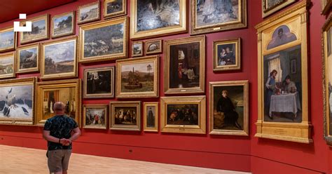 빨간색과 검은색 체크무늬 셔츠를 입은 여자가 그림 앞에 서 있다 사진 Unsplash의 무료 예술 이미지