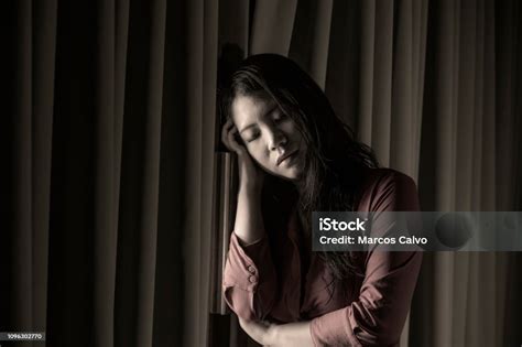 극적인 실내 여자의 초상화 젊은 슬 프 고 우울 아시아 한국 울고 우울증과 가정에서 어두운 빛에 불안을 겪고 절망 실의 커튼 슬픔 개념에 창 감정에 대한 스톡 사진 및 기타