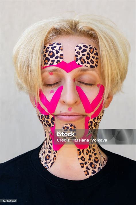 아름다운 여자 45 세 백인 미적 테이핑 절차 표범 스타일과 분홍색 테이프의 색상 스파 살롱 주름과 피로에 대한 노화 방지