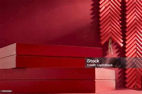 로우 앵글 뷰는 두 개의 직사각형 상자가 쌓여 진홍색 배경에 두 개의 끈 폭죽으로 장식된 프레젠테이션 제품을 위한 빈 공간을 만드는 것을 보여줍니다 중국 설날 테마입니다 0