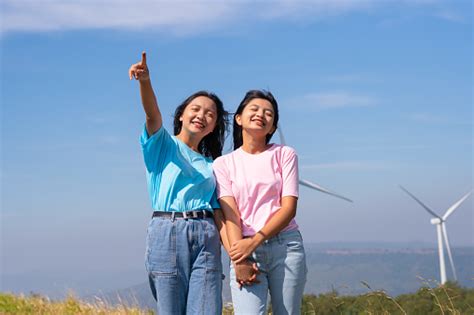 푸른 하늘이 있는 풍력 터빈과 산을 바라보며 함께 서 있는 행복한 두 소녀 Khao Yai Thieng 전기 풍력 터빈 태국 16 17 살에 대한 스톡 사진 및 기타 이미지
