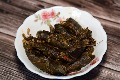 포장 된 포도 잎 한 접시는 이집트 Mahshi를 채우고 흰 쌀 양파 파슬리 딜 및 고수풀로 가득 차 있으며 Mahshy의 아랍 이집트 전통 요리의 선택적 초점이