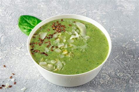 시금치 아보카도 셀러리 키위 코코넛 밀크의 그린 스무디 그릇은 코코넛 플레이크 아마씨와 함께 제공됩니다 가정 요리 비건 건강 해독 식사 식이 및 Weght 손실 브로콜리