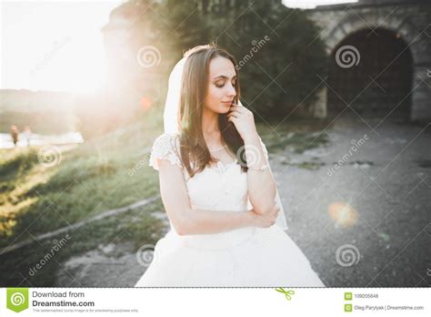 Beautiful Elegant Bride With Perfect Wedding Dress And Bouquet Posing Near Old Castle Stock