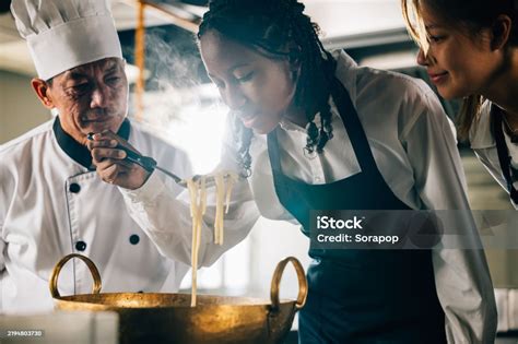 요리사가 부엌에서 국수를 요리하는 학생들에게 가르칩니다 교복을 입은 여고생들이 라면 스프를 만들고 있다 선생님은 웃는 아이들을 지도합니다 현대 교육 즐거운 저녁 식사 만들기