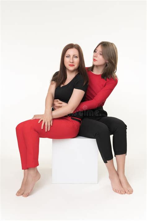 Mom And Daughter Sits On White Box On White Background Teenager