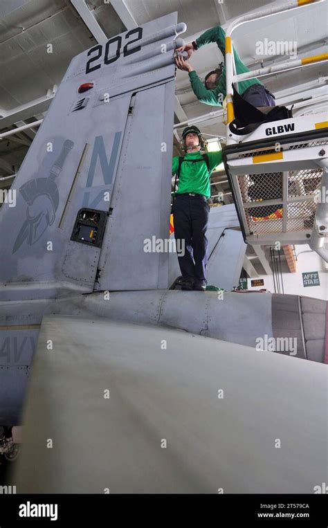US Navy Sailors Install An Antenna Onto The Left Vertical Stabilizer Of An F18E Super Hornet