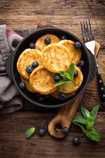 맛 있는 코 티 지 치즈 팬케이크 또는 배경에 어두운 나무 시골풍 보기 위의 주철 냄비에 신선한 블루베리와 Syrniki 맛 있는 아침 식사 가정 주방에 대한 스톡 사진 및